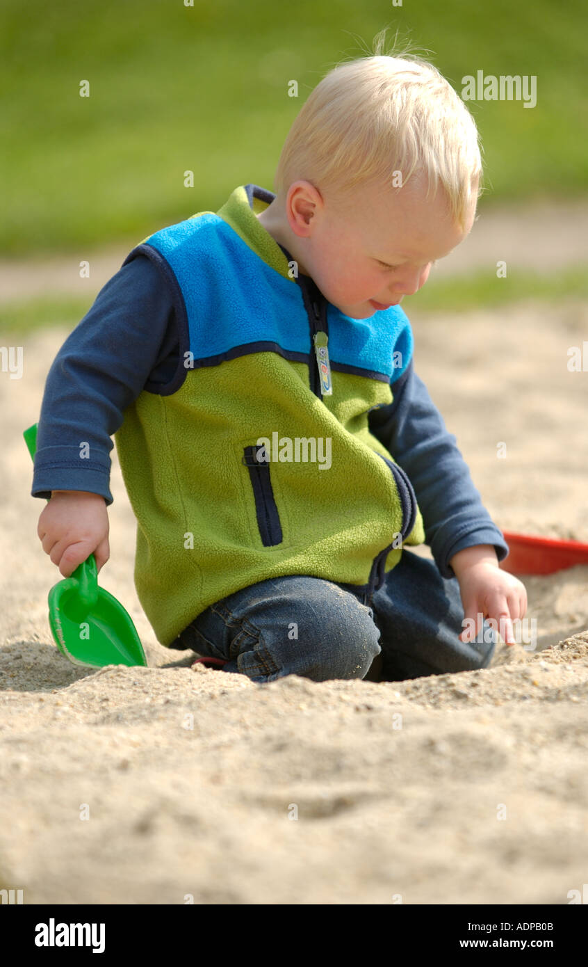 Little boy playing with sand Stock Photo - Alamy