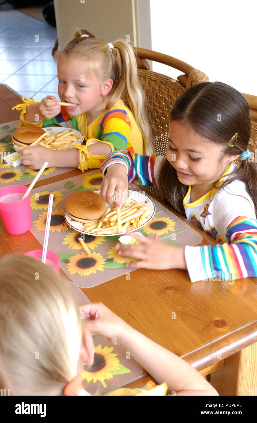 Three girls eating hamburger Stock Photo - Alamy