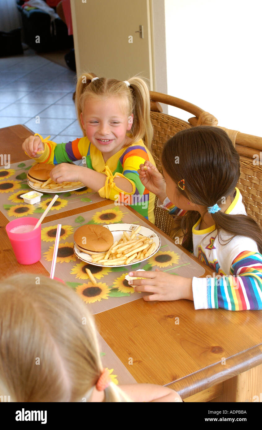 Three girls eating hamburgers Stock Photo - Alamy
