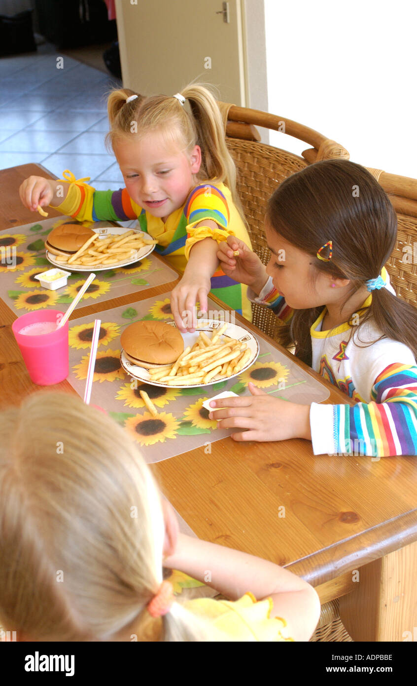 Three girls eating hamburger Stock Photo - Alamy