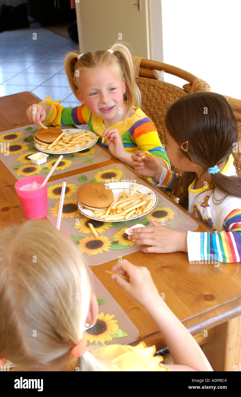 Three girls eating hamburger Stock Photo - Alamy