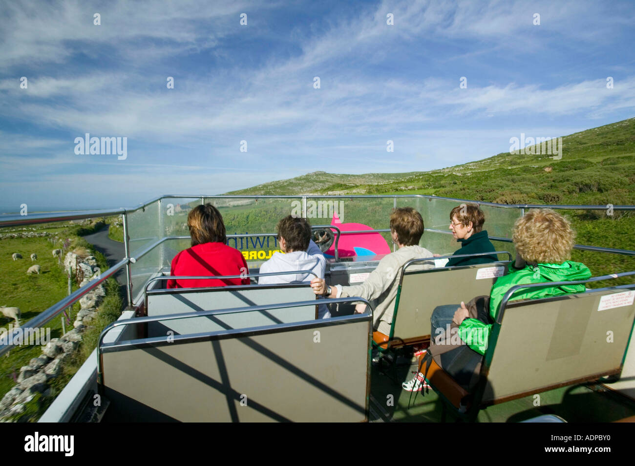 tourists on an open topped bus travelling through the Cornish ...