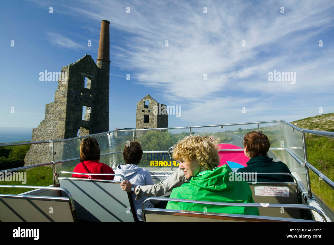 tourists on an open topped bus travelling through the Cornish ...