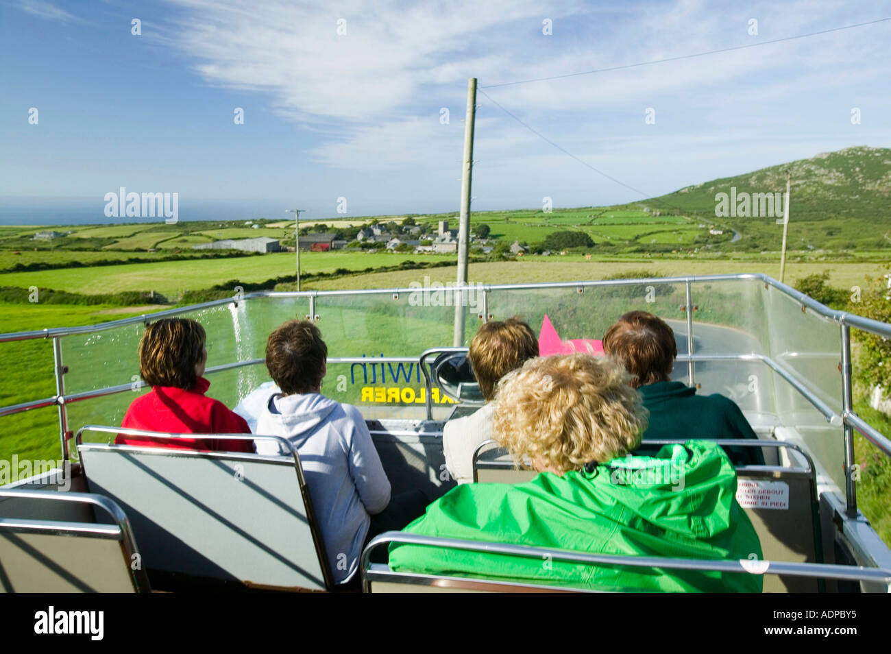 tourists on an open topped bus travelling through the Cornish ...