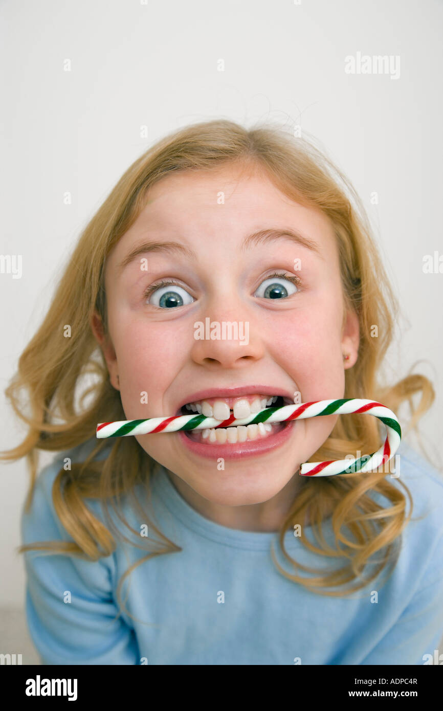 Young girl holding a candy cane between her teeth Stock Photo - Alamy