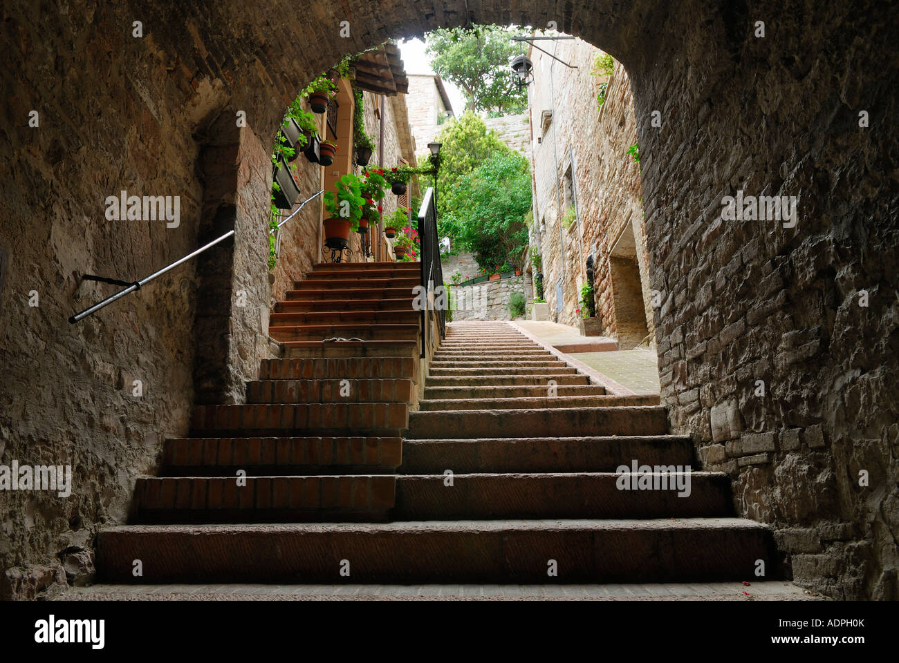 Steep hillside steps in a stone tunnel alleyway in Assisi Umbria Italy ...