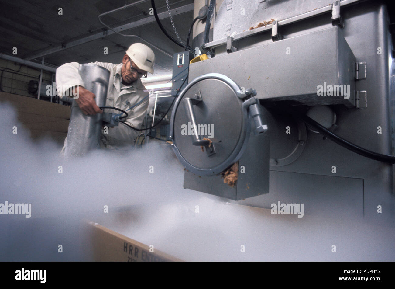 A worker adjusts a machine for flash freezing food Stock Photo - Alamy
