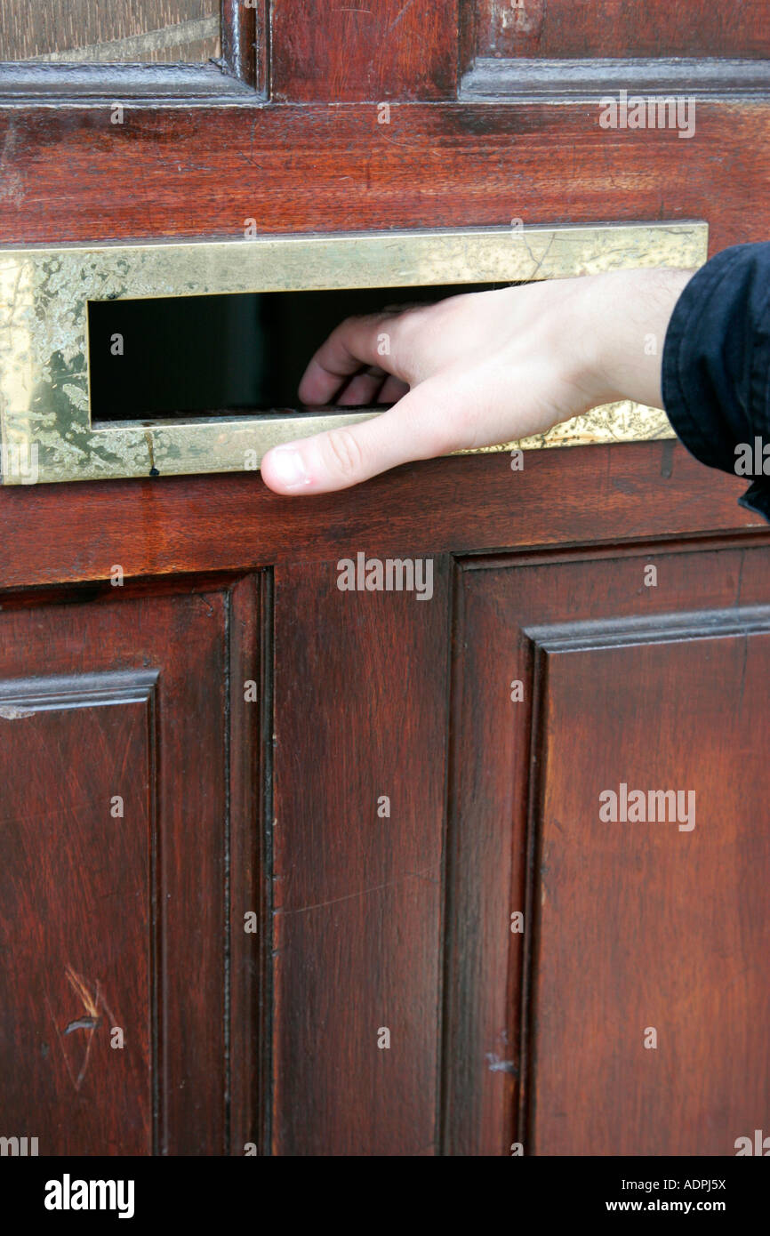 mans hand trying brass letterbox putting hand through letterbox cold ...