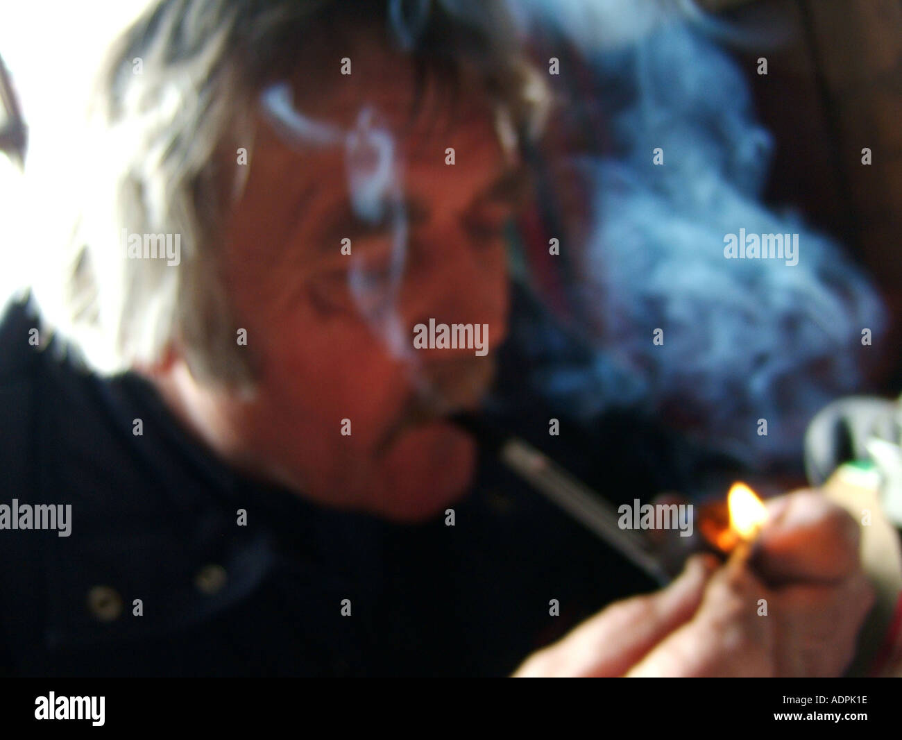 man lighting pipe Stock Photo - Alamy