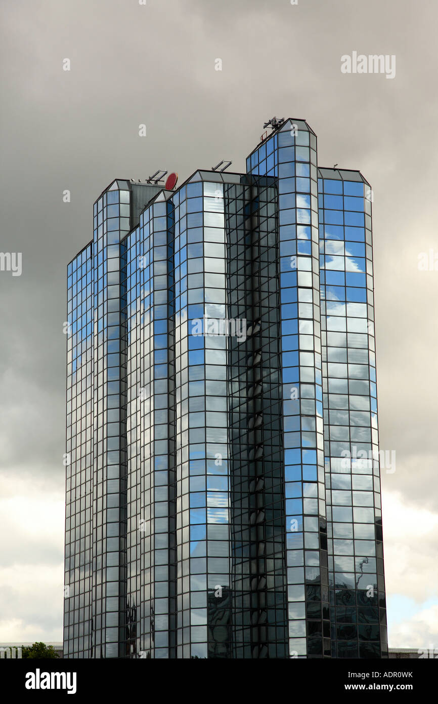 Glass fronted building with storm clouds behind Stock Photo - Alamy