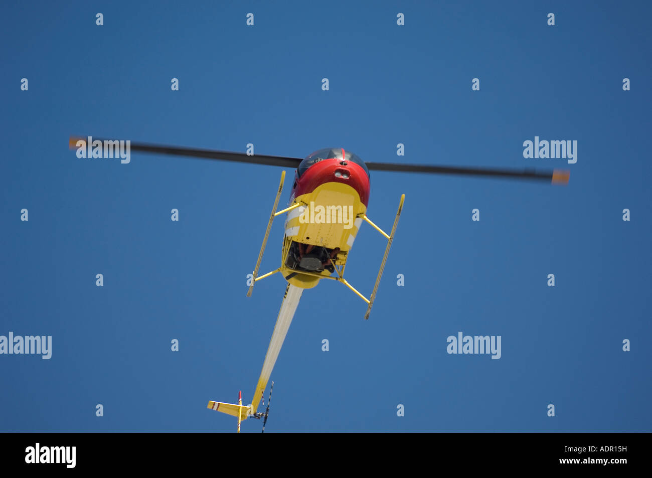 helicopter rotor Robinson R44 red yellow rotor blue sky below above fly ...