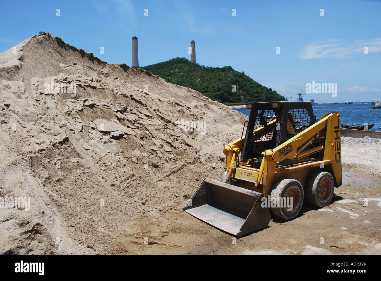 MINI DIGGER NEXT TO PILE OF SAND ON CONSTRUCTION SITE WITH POWER ...