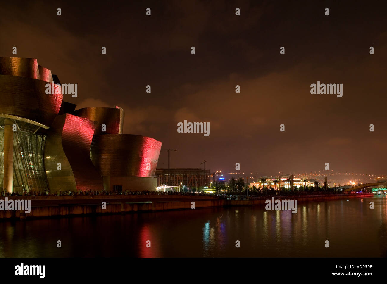Guggenheim Museum Bilbao at night illuminated in red by the light of ...