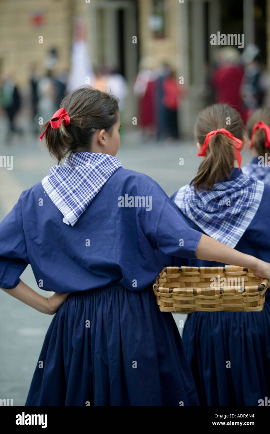 Basque girls dressed in blue and carrying wicker baskets perform a ...