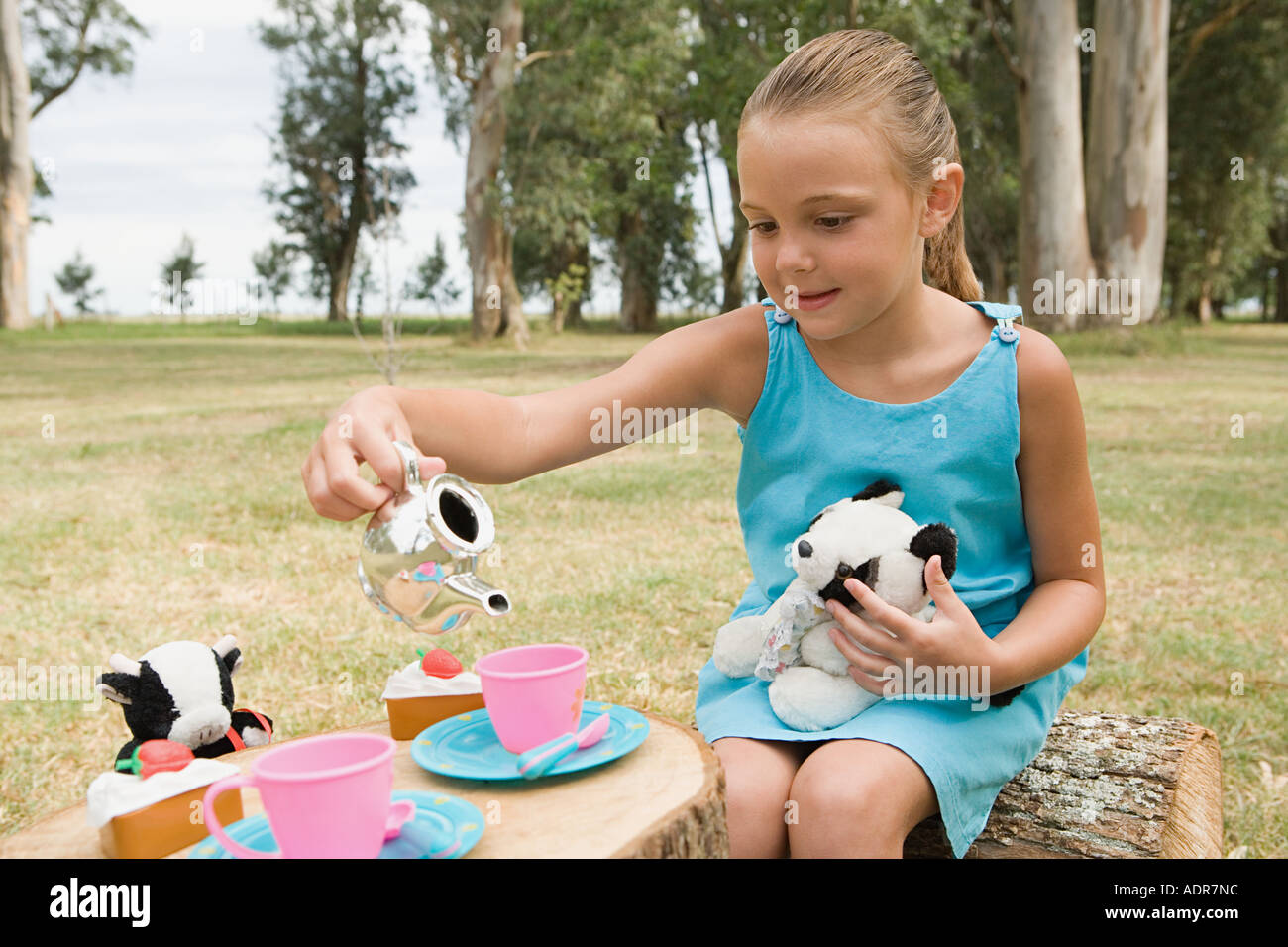 Girl having a tea party with soft toys Stock Photo - Alamy