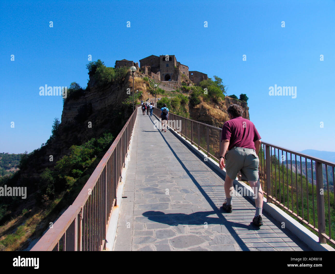 Tourists make the long climb up the bridge to Civita di Bagnoregio ...