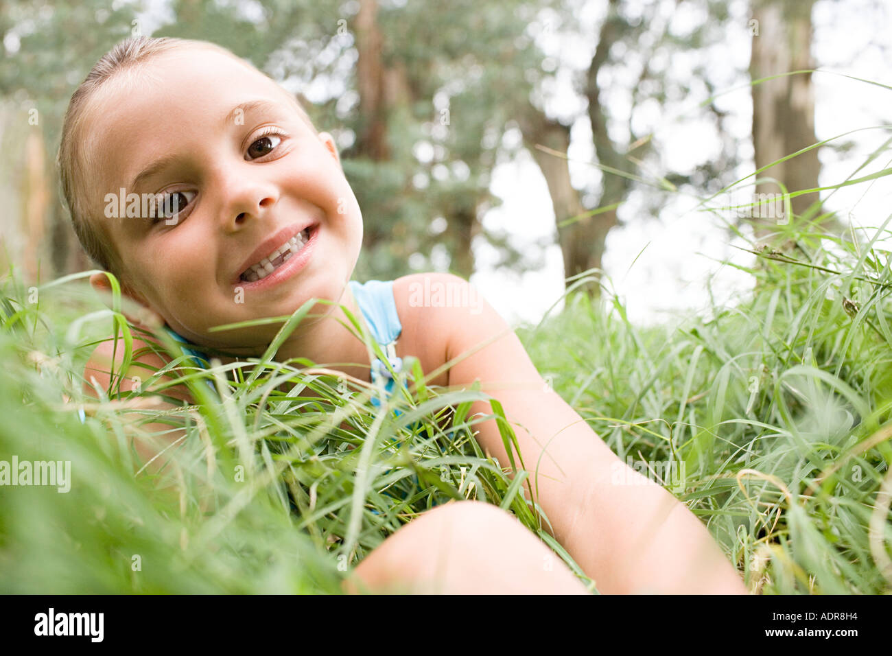 Girl sitting in grass Stock Photo - Alamy