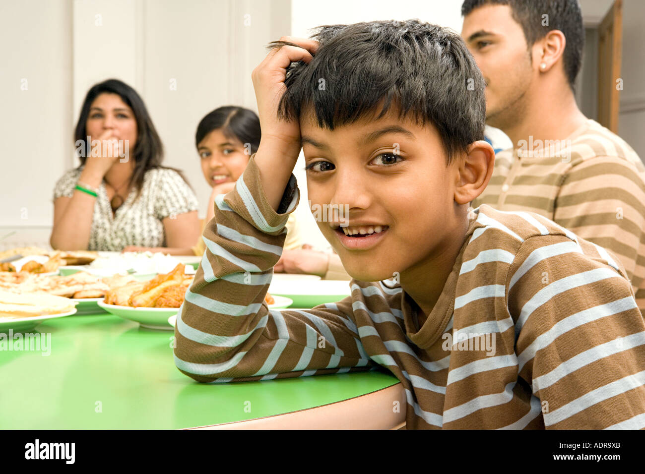 Boy with family at dining table Stock Photo - Alamy