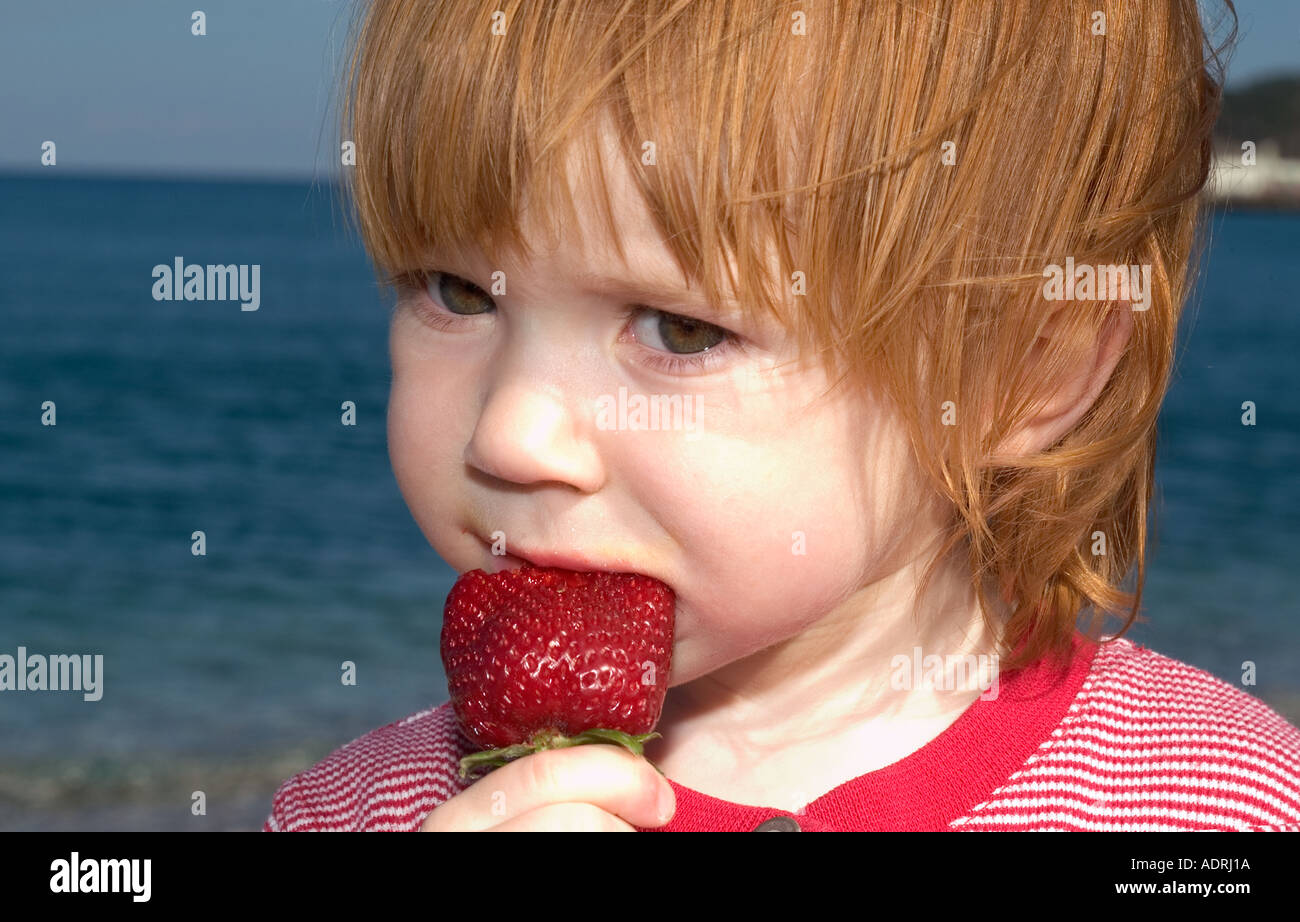 MR girl is eating a strawberry Stock Photo - Alamy