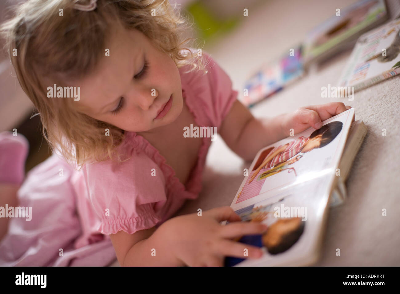 Toddler reading a book Stock Photo - Alamy