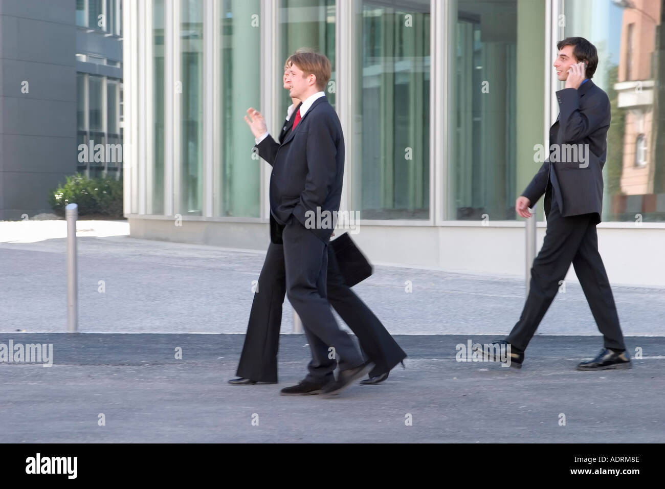 3 three businessmen strolling while lunch break in front of business ...