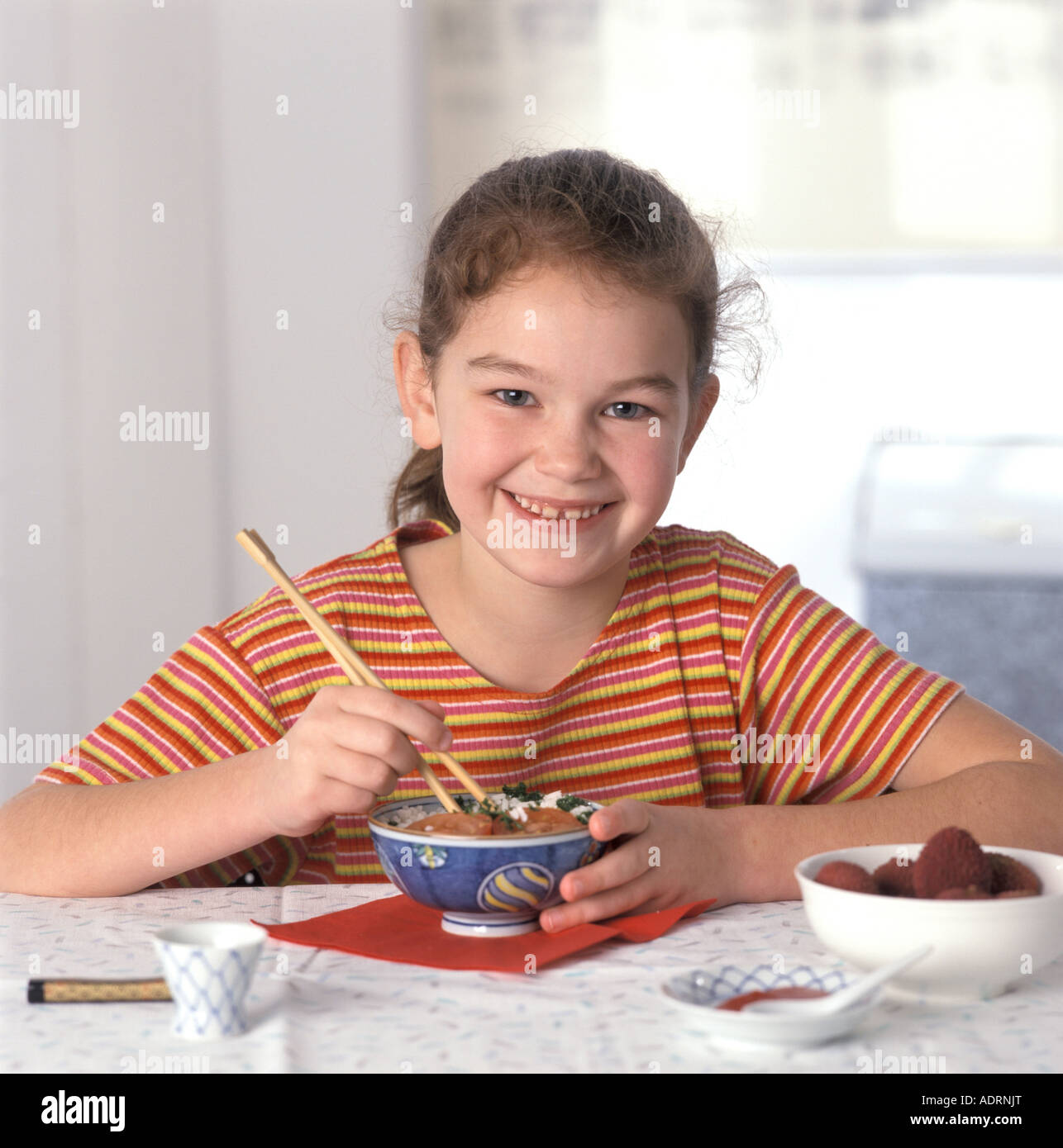 Girl with a cup of rice and chop sticks Stock Photo - Alamy