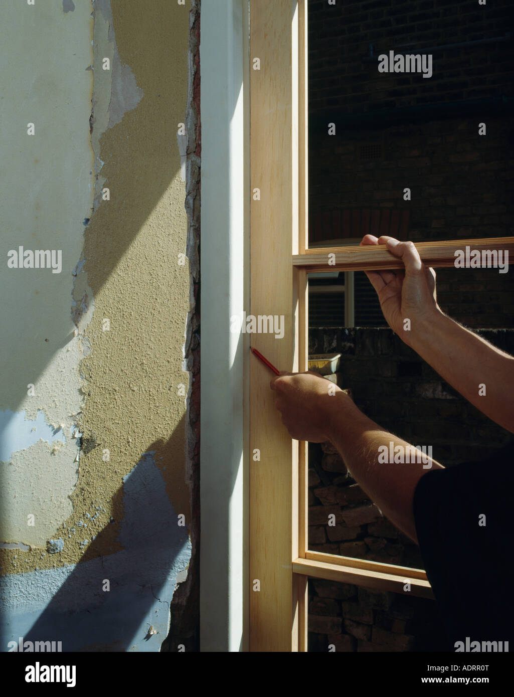 Man fitting new wooden framed window Stock Photo - Alamy