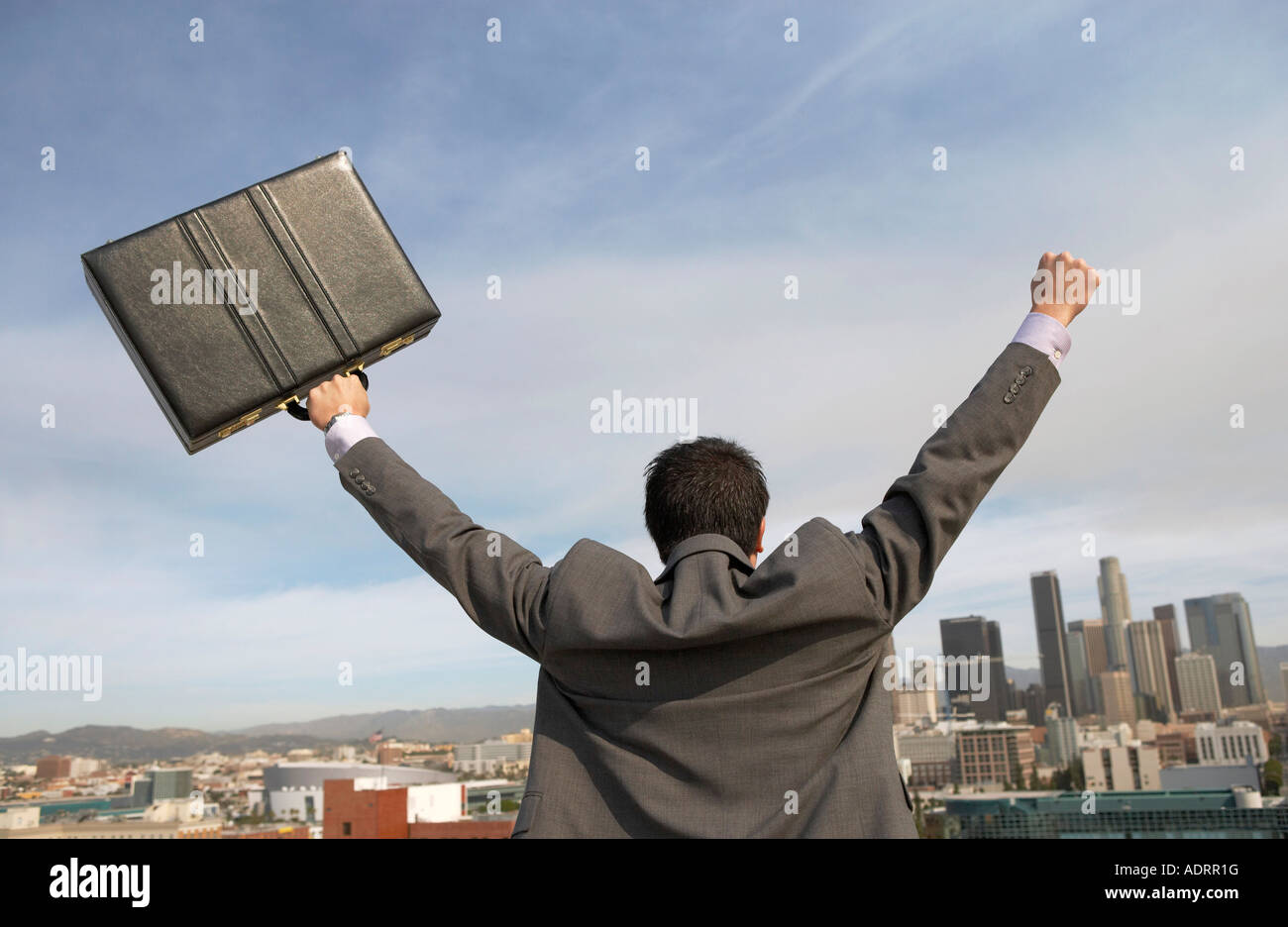 Business man cheering to city, back view Stock Photo - Alamy