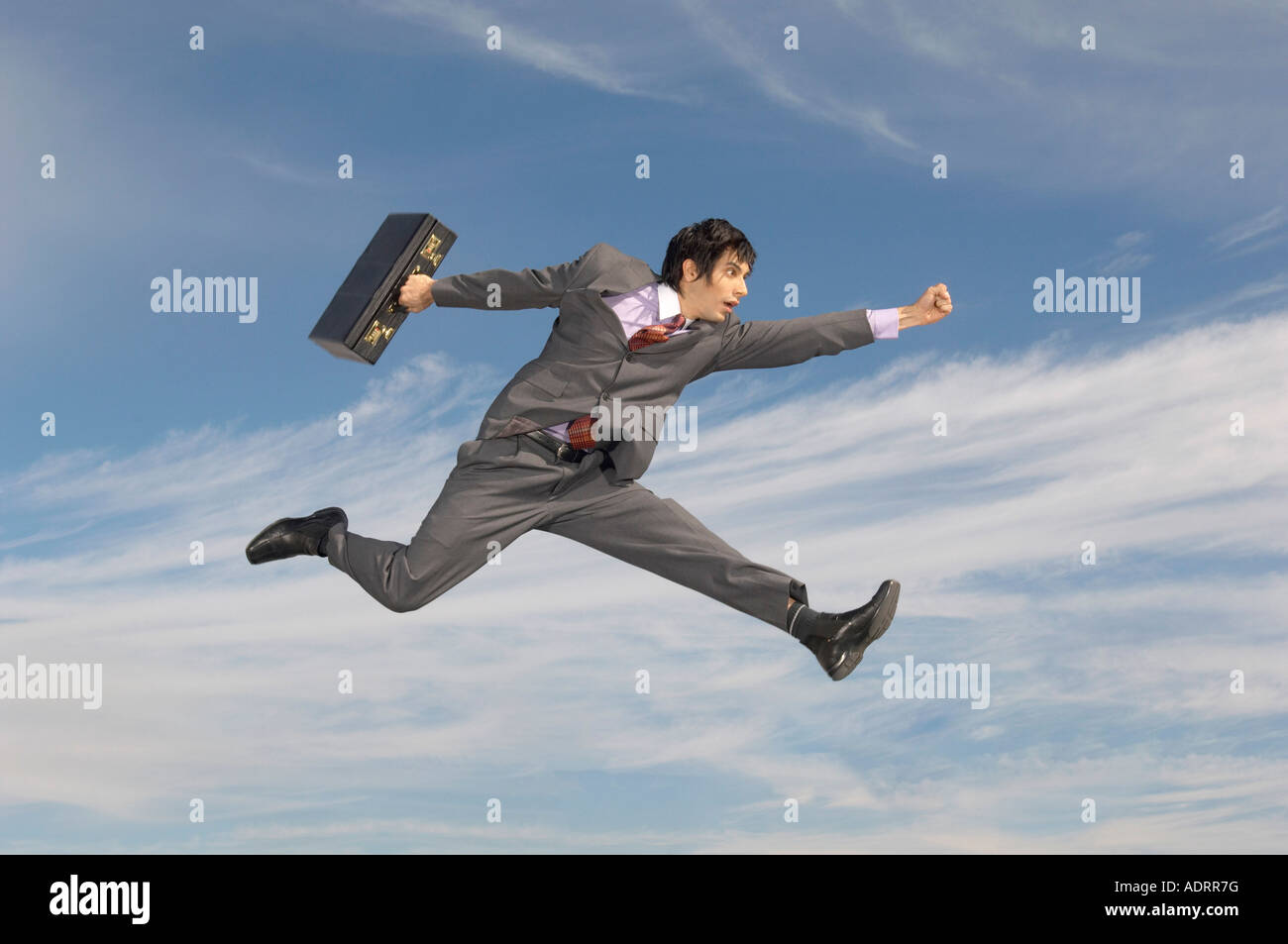 Business man running with briefcase mid-air outdoors Stock Photo - Alamy