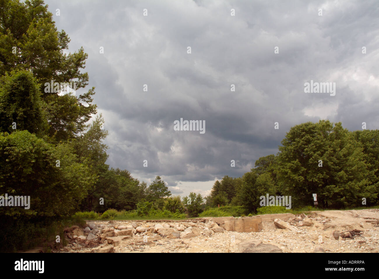A section of washed out road from water over flowing a small pond Storm ...