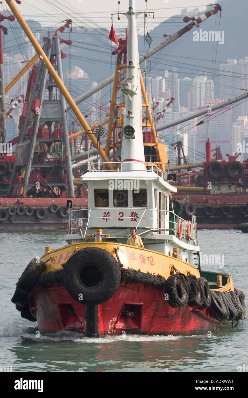 Older style hong kong tug boat with container transfer barges in ...