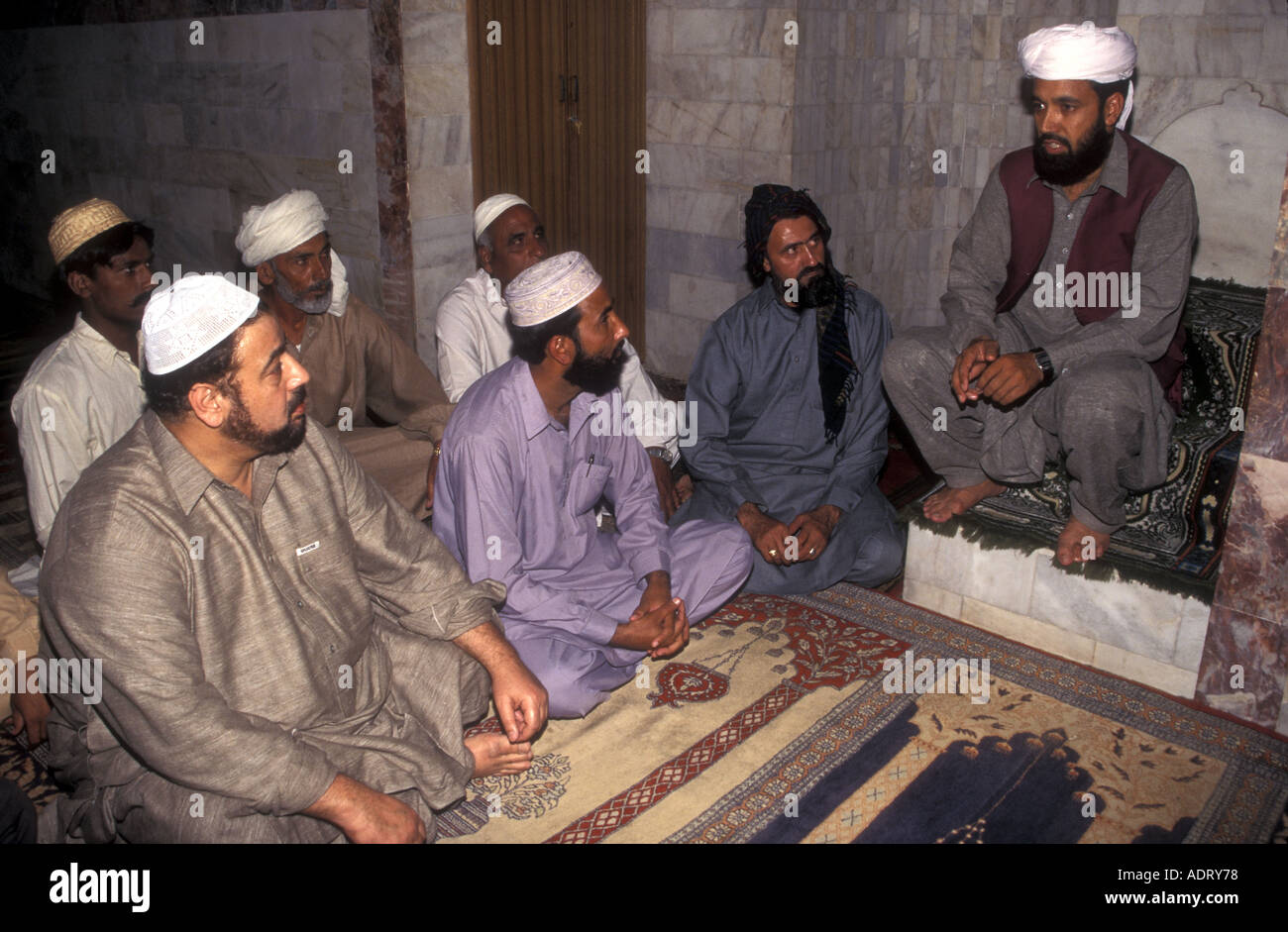 The Imam of a small mosque giving his sermon to a group of men in ...