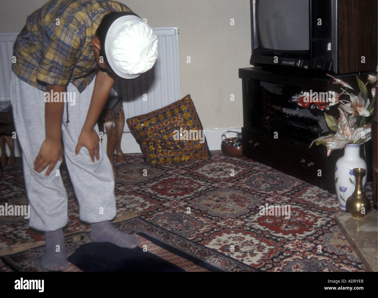 Muslim boy in the ruku, fourth prayer position at home in London Stock ...