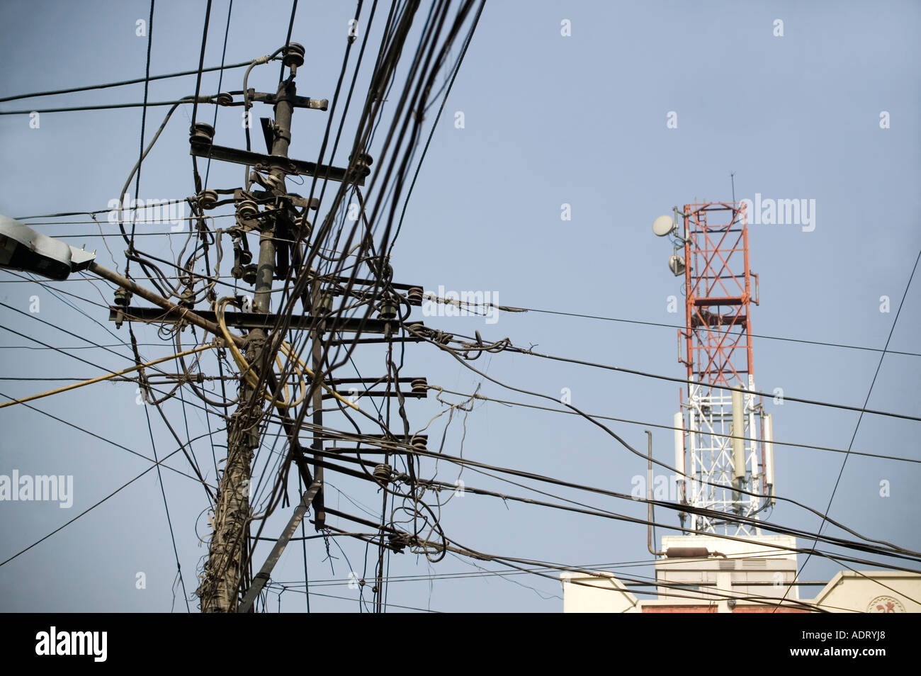Old telephone cables juxtaposed against a mobile phone mast Delhi India ...