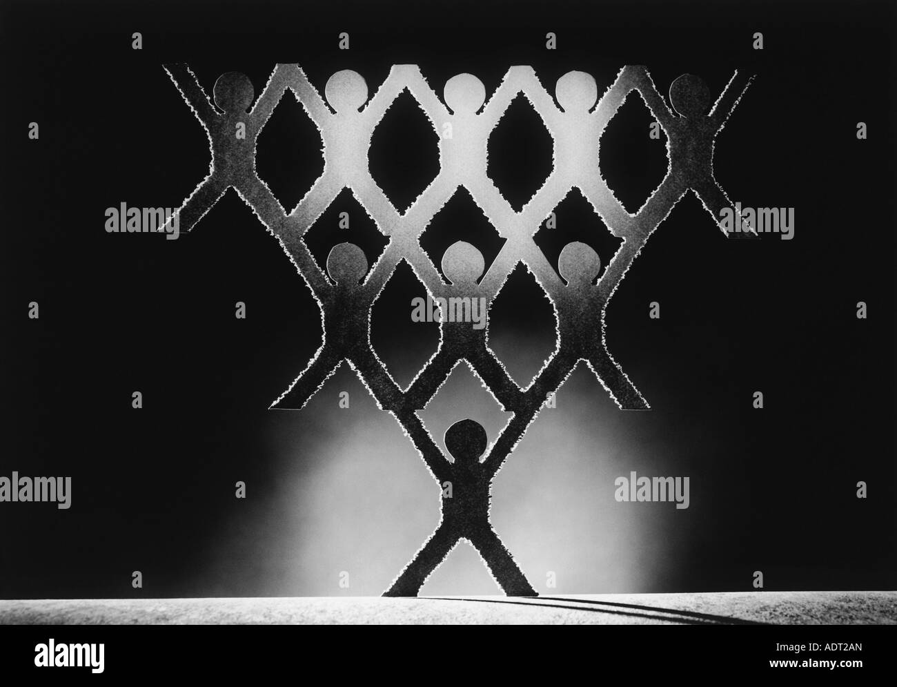 Pyramid of cut out paper figures, (b&w Stock Photo - Alamy