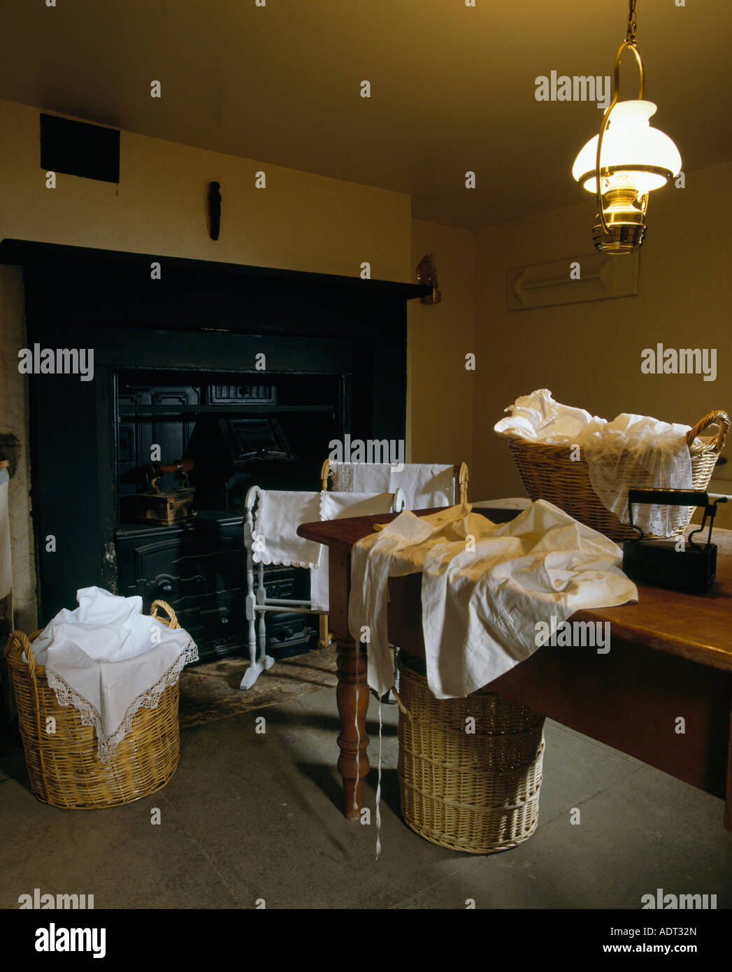 Laundry in baskets on floor and table in Victorian kitchen Stock Photo ...