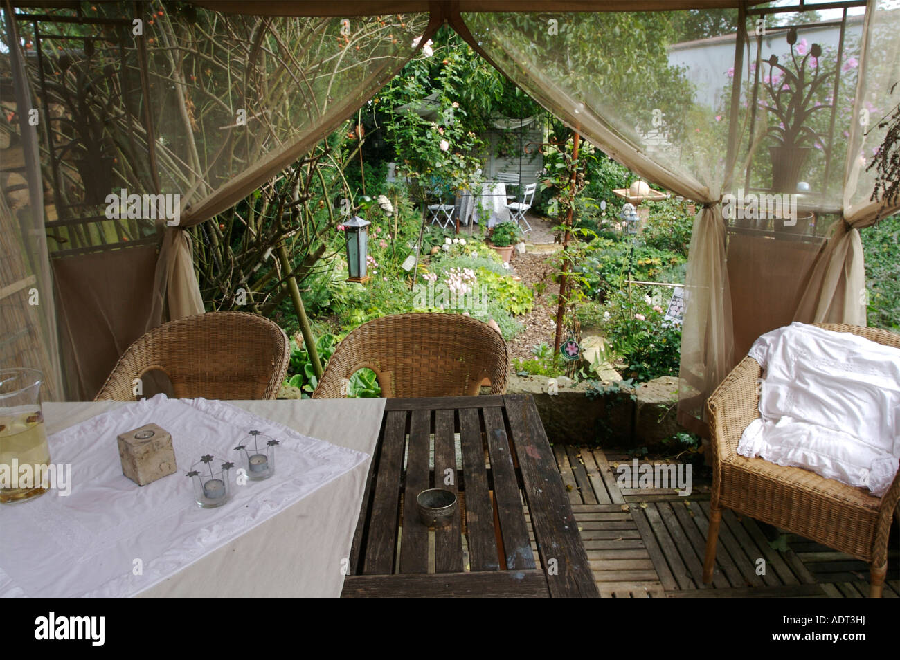 Look into a garden pavilion with chairs made of rattan and an old ...