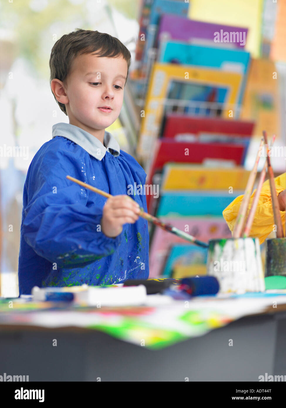 Boy painting in art class Stock Photo - Alamy