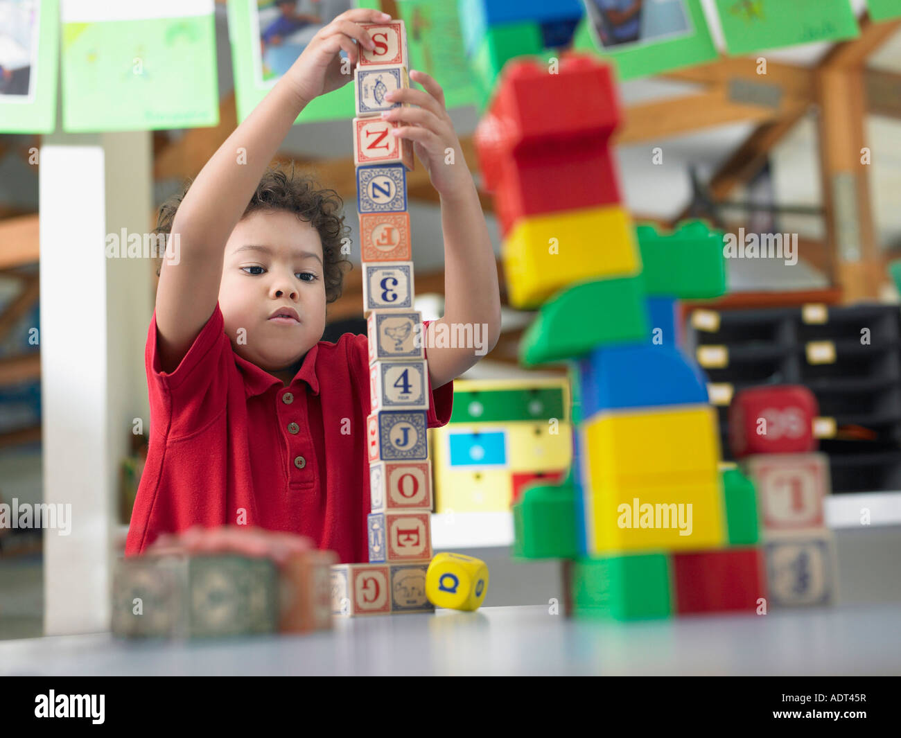 Boy playing with alphabet blocks in classroom Stock Photo - Alamy