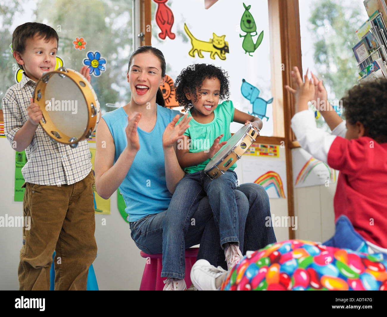 Children with teacher playing music in classroom Stock Photo - Alamy