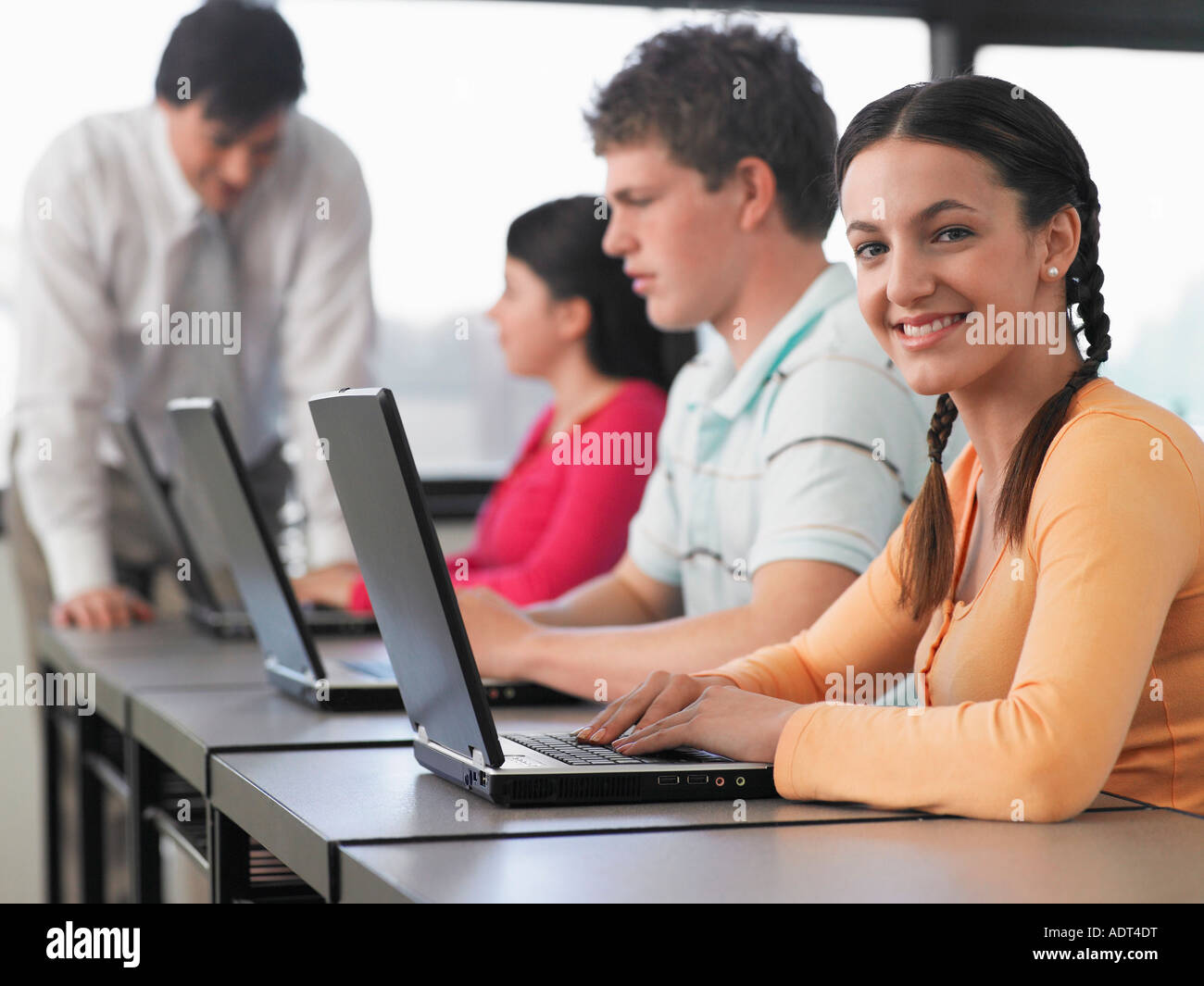 Row of teenage students using laptops in classroom Stock Photo - Alamy