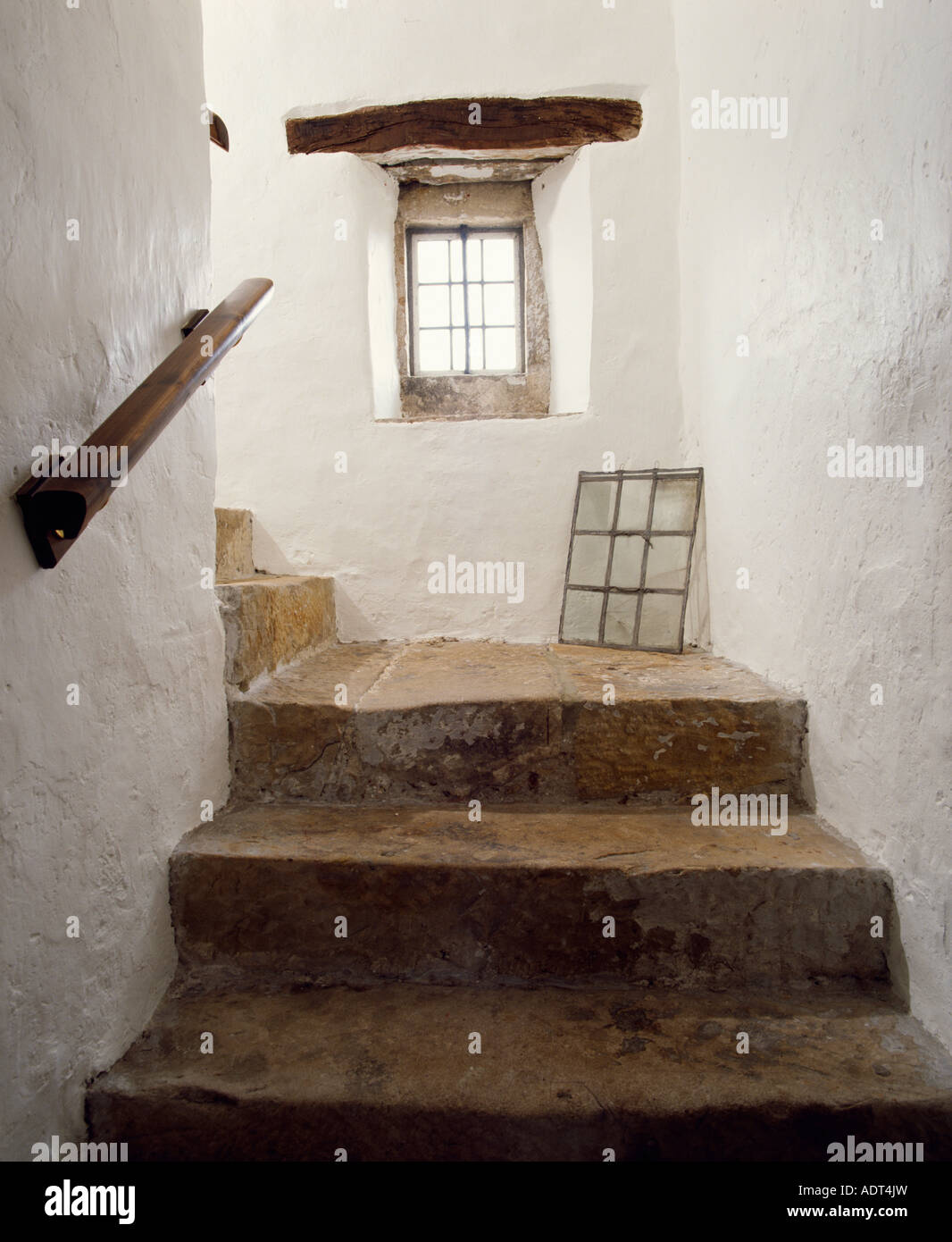 Stone staircase below small alcove window above old window resting on ...