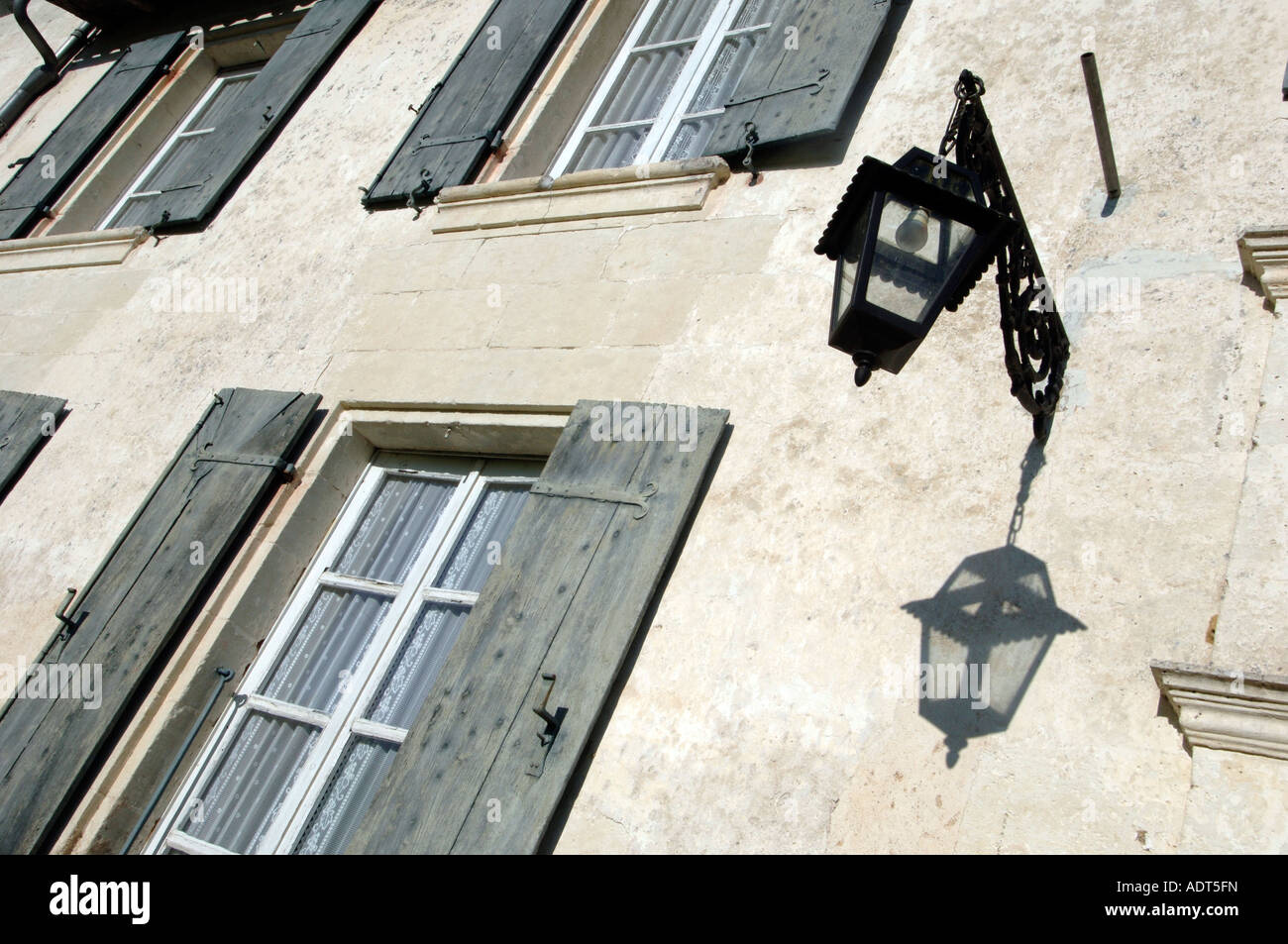 A lamp creates a shadow on an old French manor house with window ...