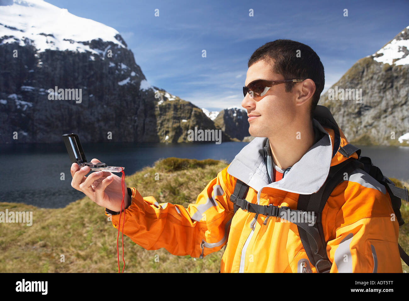 Hiker using compass in mountains Stock Photo - Alamy