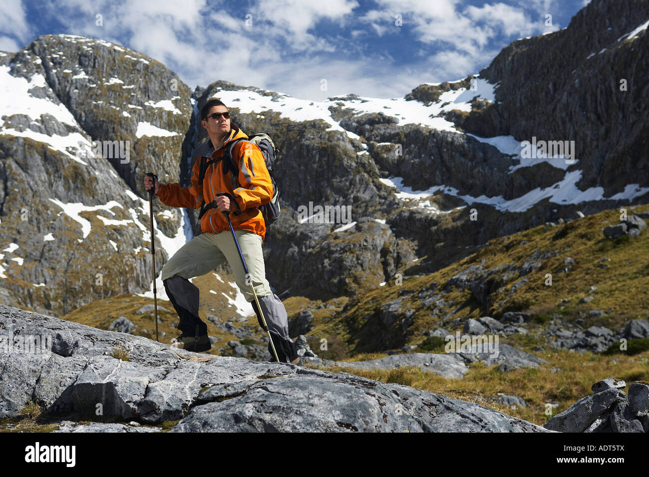 Hiker with walking sticks in mountains Stock Photo - Alamy