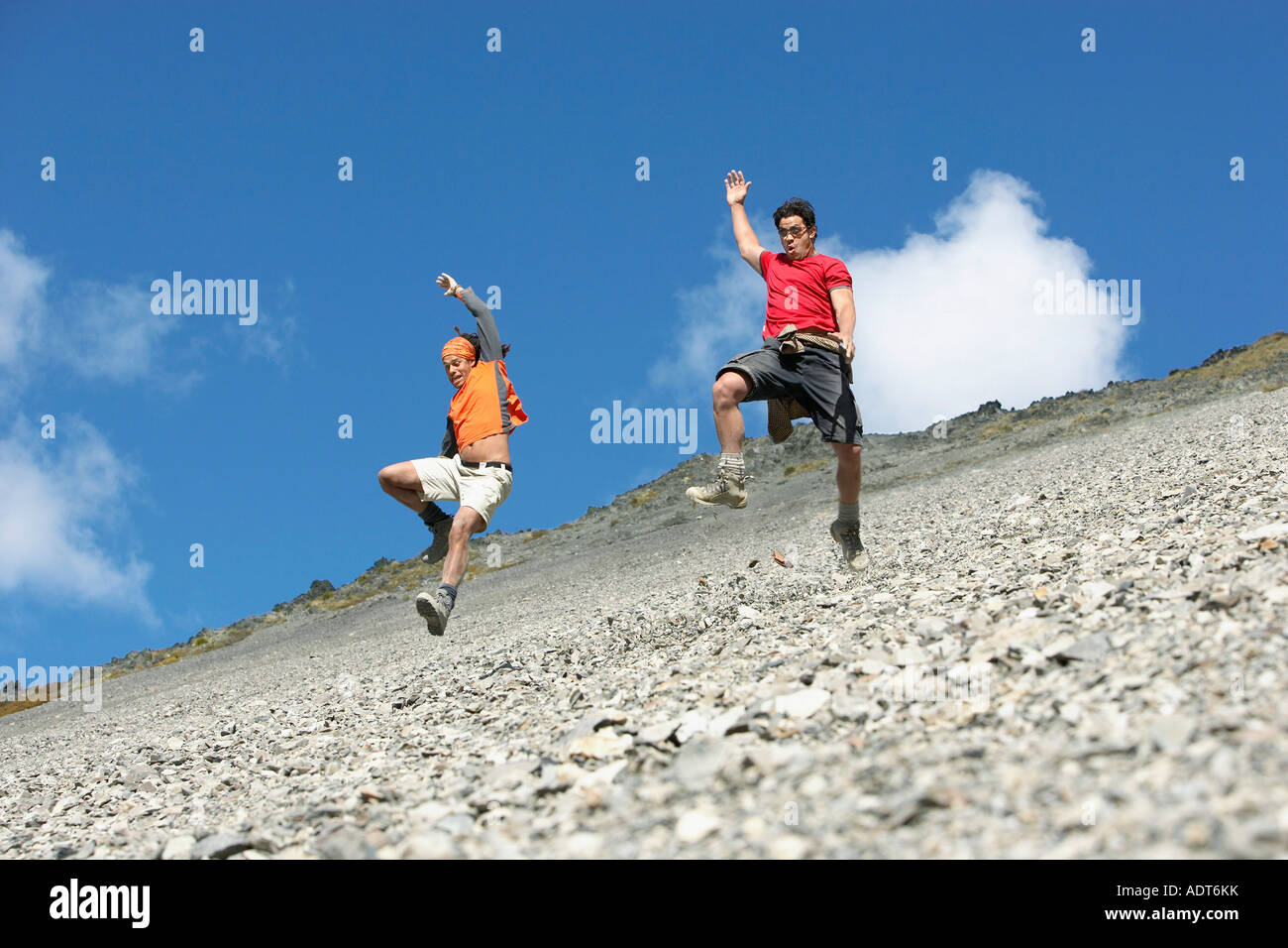 Two men jumping down screen field Stock Photo - Alamy