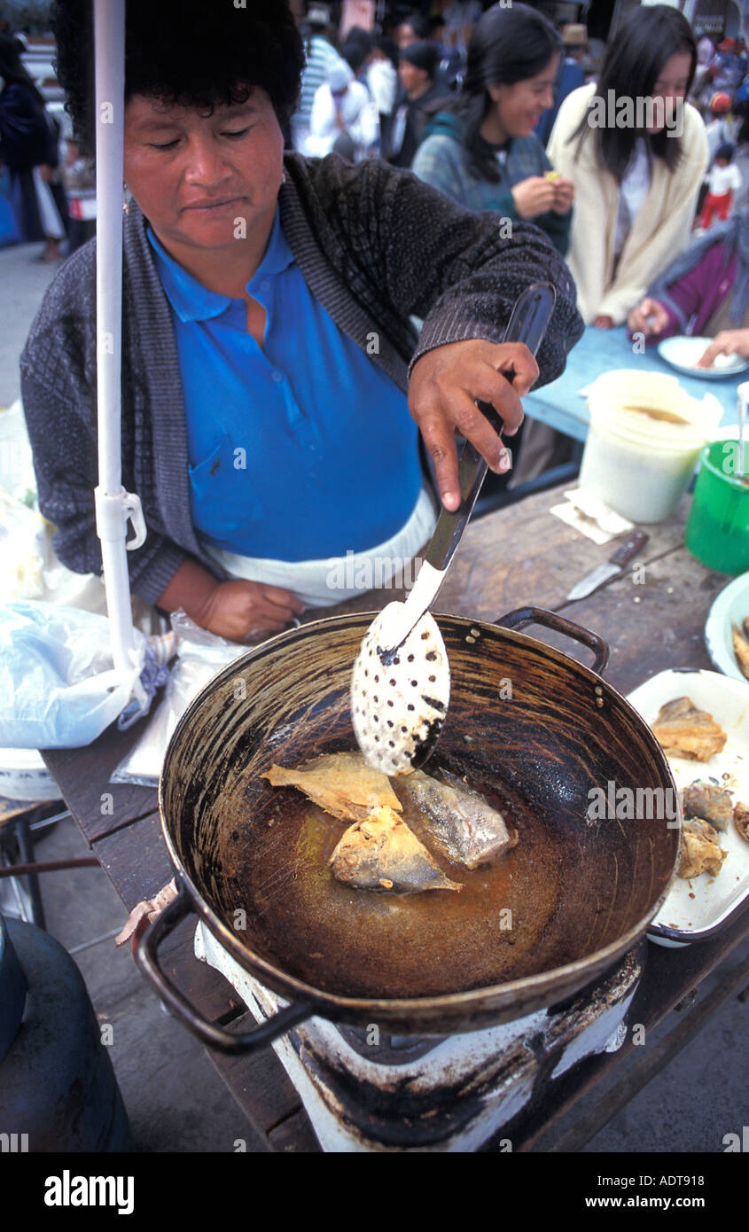 Ecuadorean woman frying fish at the market in Otavalo Otavalo is one of ...