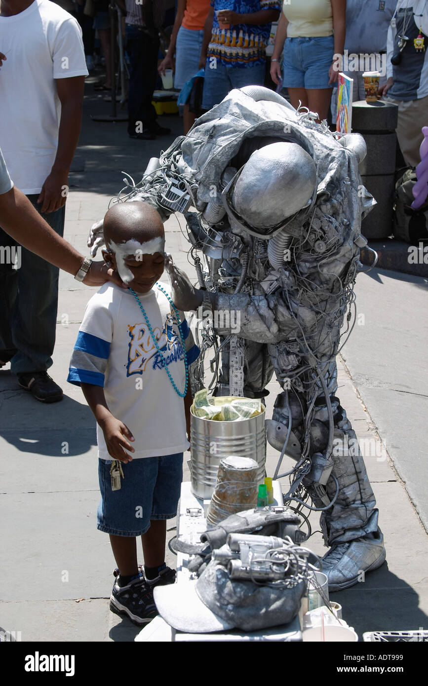 A street performer paints a young boy with silver paint Stock Photo - Alamy