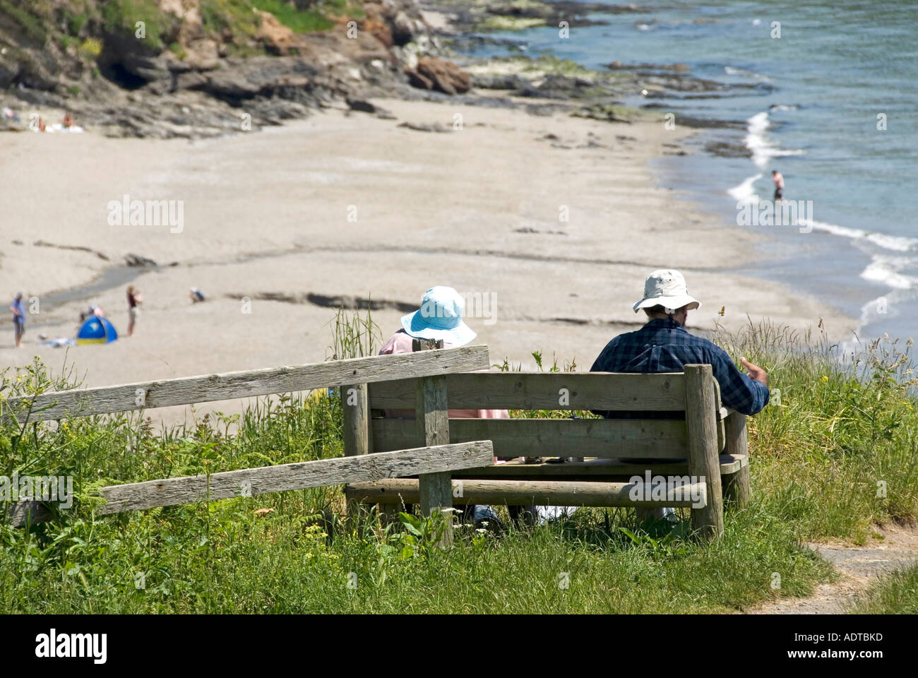 Pendower Beach at Gerrans Bay couple wearing sun hats relaxing on ...