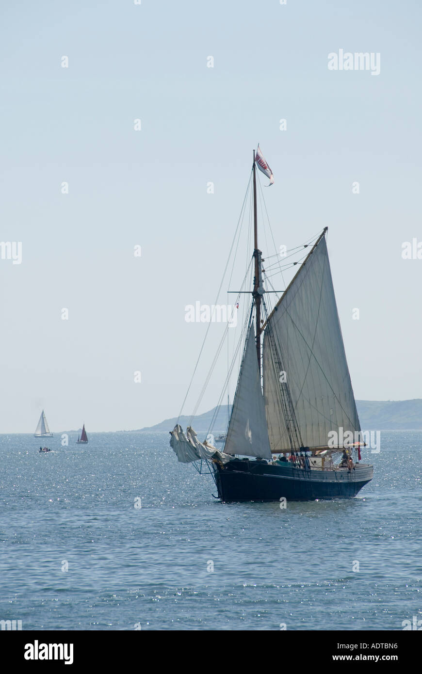Off Cornish town of St Mawes sailing boat under sail on Percuil River ...